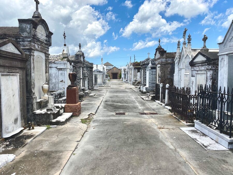 Historic above ground cemetery tombs and vaults under a blue sky