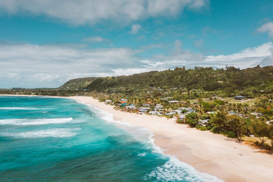 Aerial view of a tropical Hawaiian beach with turquoise waters and lush greenery