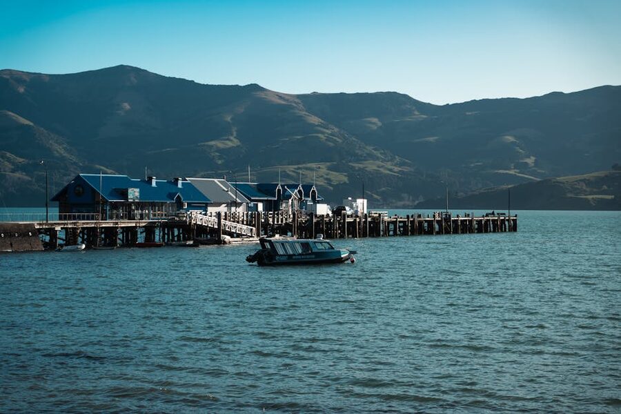 Akaroa wharf with cabins and surrounding mountains