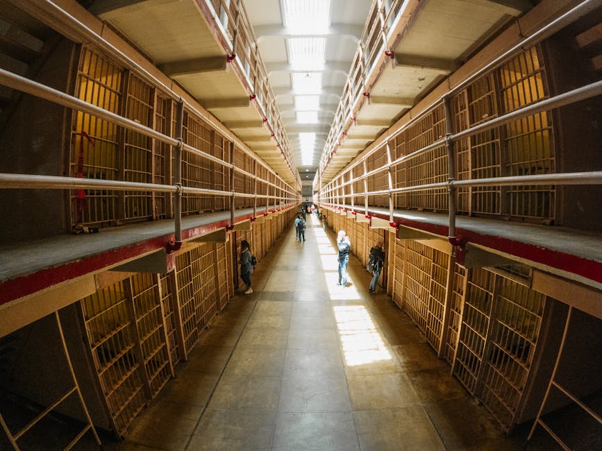 Visitors touring the main cellhouse corridor at Alcatraz with audio guides