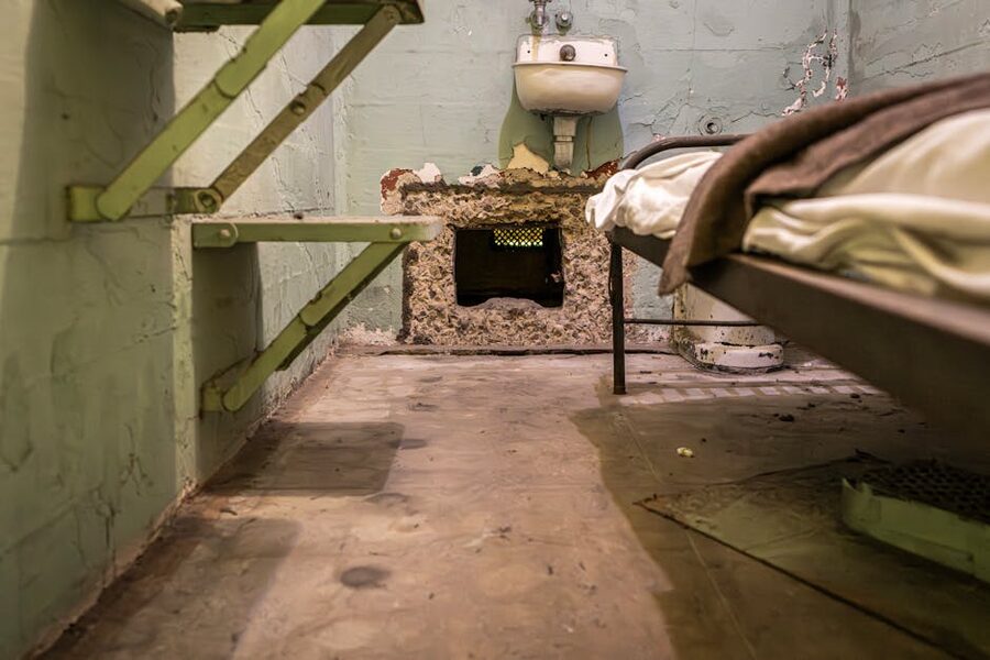 Interior of a preserved Alcatraz prison cell with bunk bed and small sink