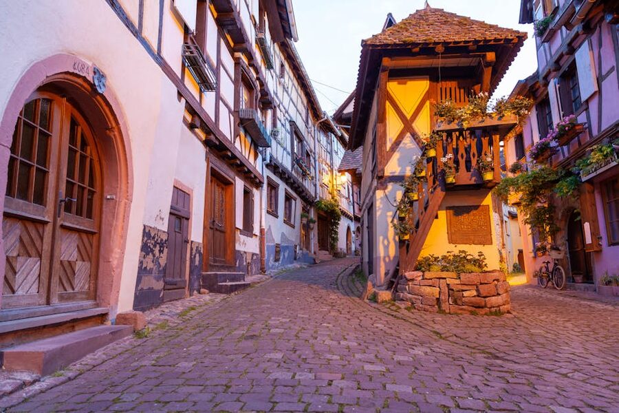 Eguisheim cobblestone alley with flowers and timber-frame architecture