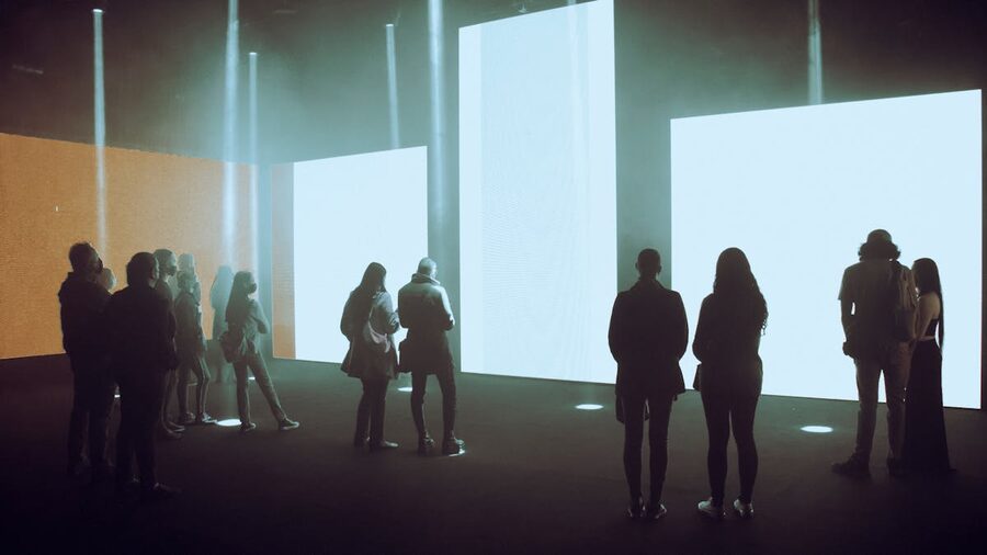 Visitors exploring immersive digital art exhibition with illuminated projections