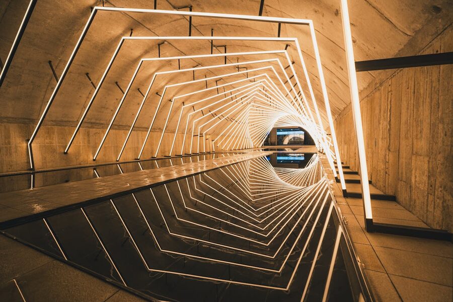 Modern LED tunnel with geometric patterns reflecting on water