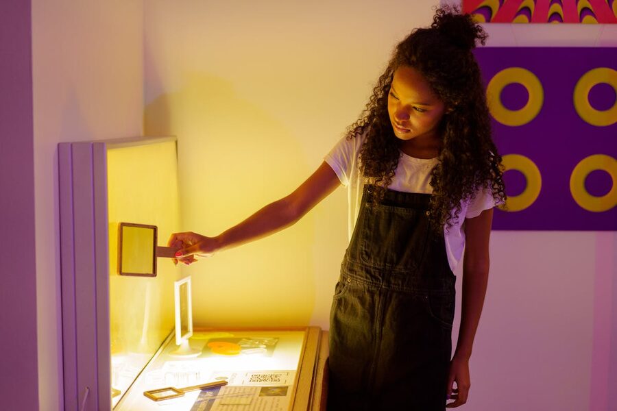 Teenager exploring interactive art exhibit with colorful visuals