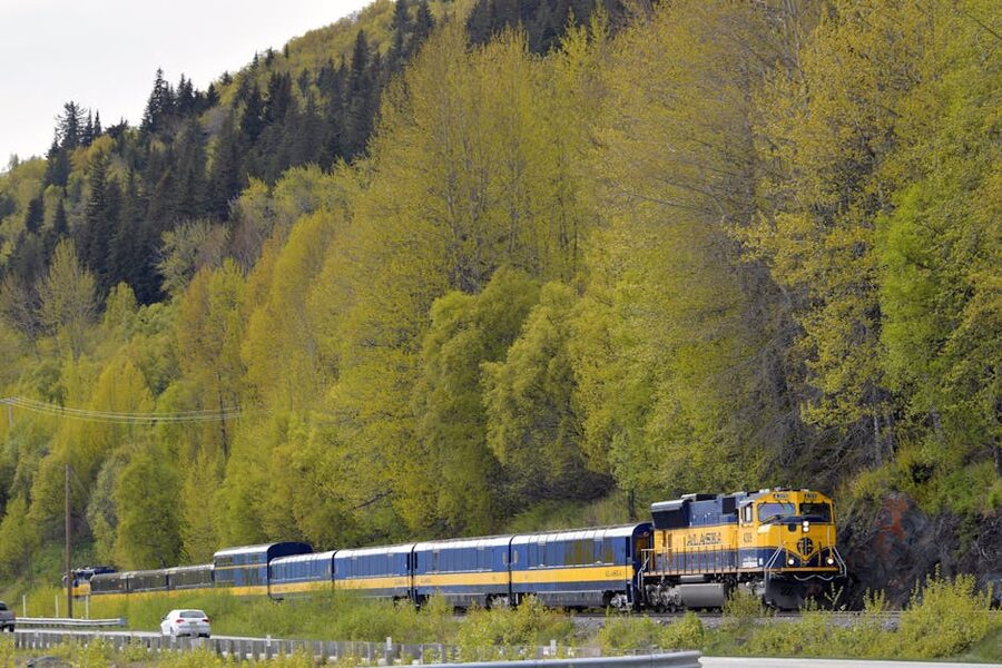 Alaska Railroad passenger train traveling through forest near Anchorage