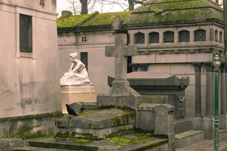 Atmospheric Père Lachaise scene with crow and statues