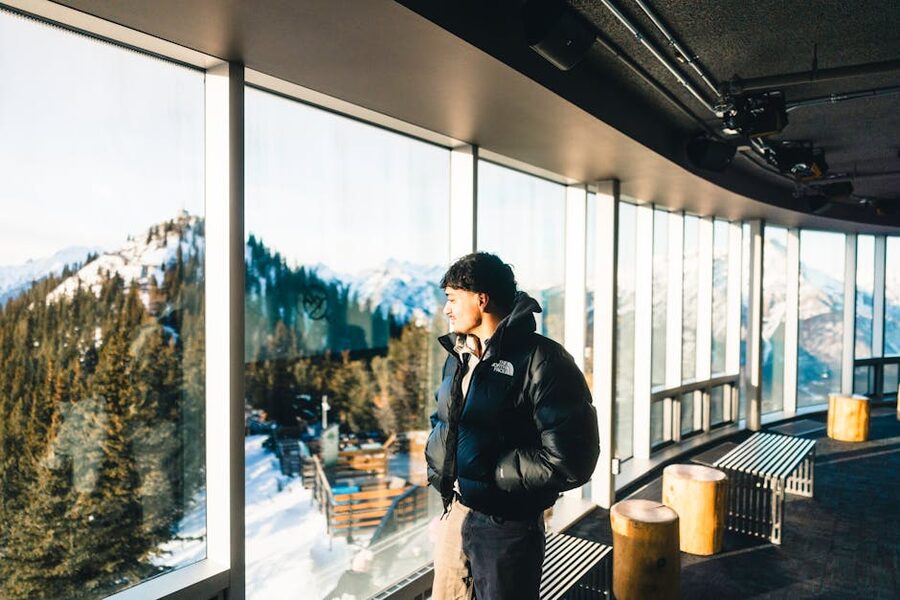 Visitor looking over snowy Sulphur Mountain summit view in winter