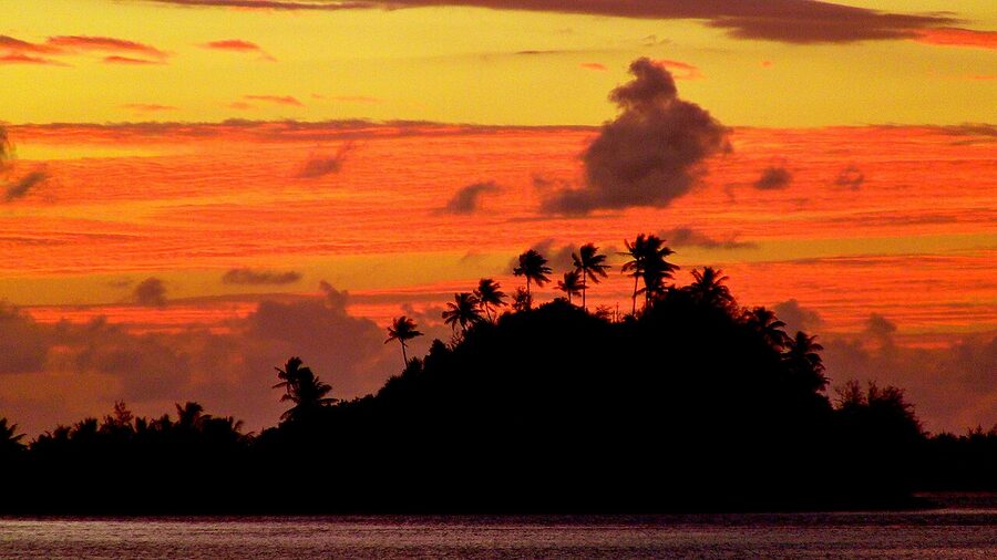 Sunrise over Marara Beach and a motu in Bora Bora