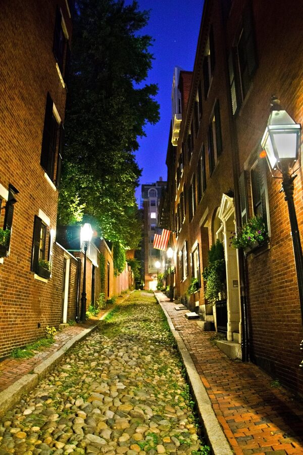 Acorn Street at night on Beacon Hill, Boston, cobblestones lit by lanterns