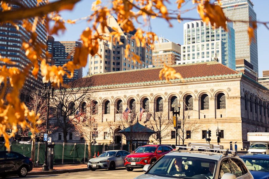 Boston Public Library stone facade framed by autumn leaves