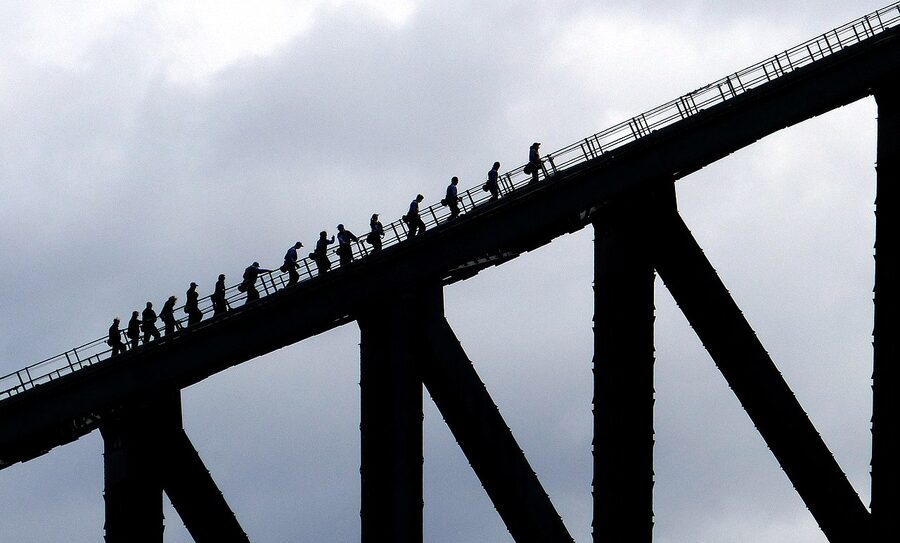 BridgeClimb Sydney participants in suits on the Sydney Harbour Bridge arch