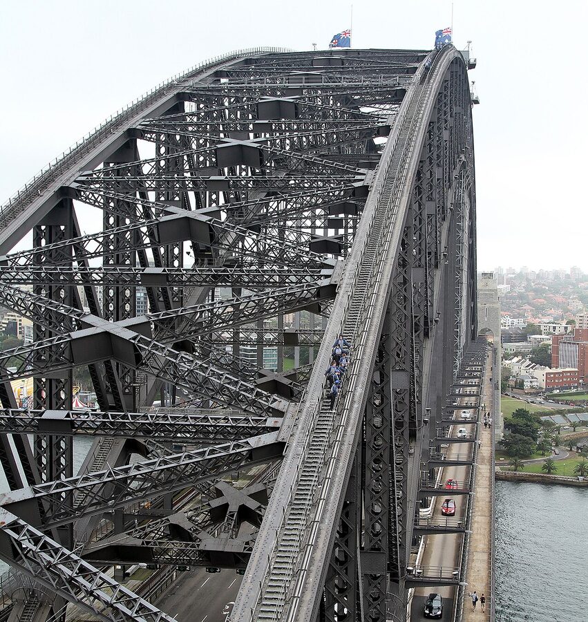 BridgeClimb participants in grey suits on top of Sydney Harbour Bridge