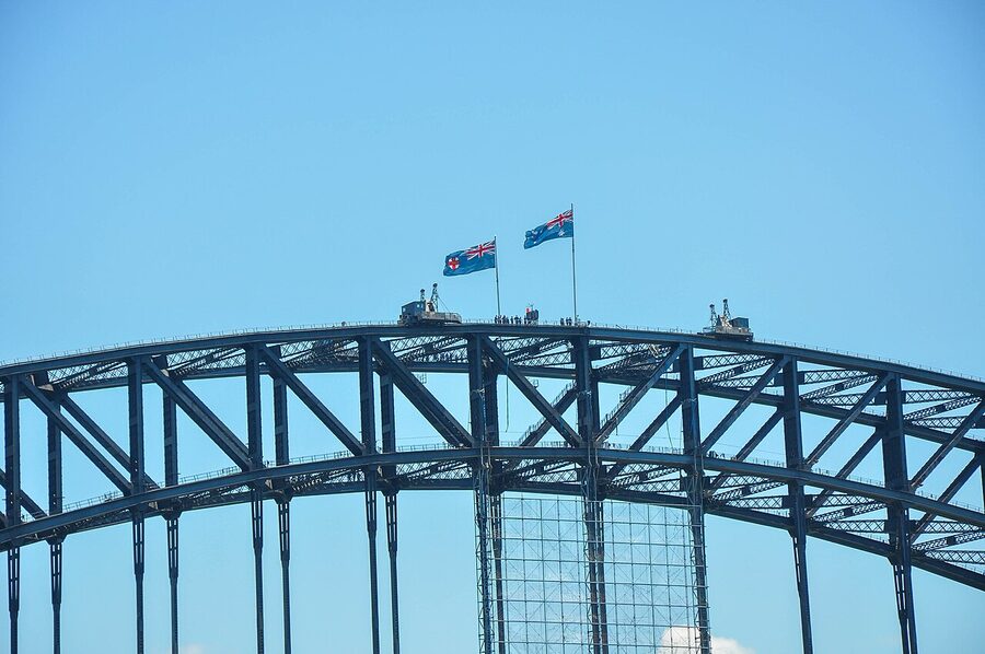Distant view of climbers walking along the top of the Sydney Harbour Bridge arch