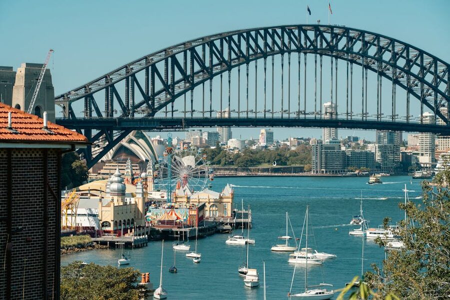 Sydney Harbour Bridge with Luna Park sign and sailing boats below