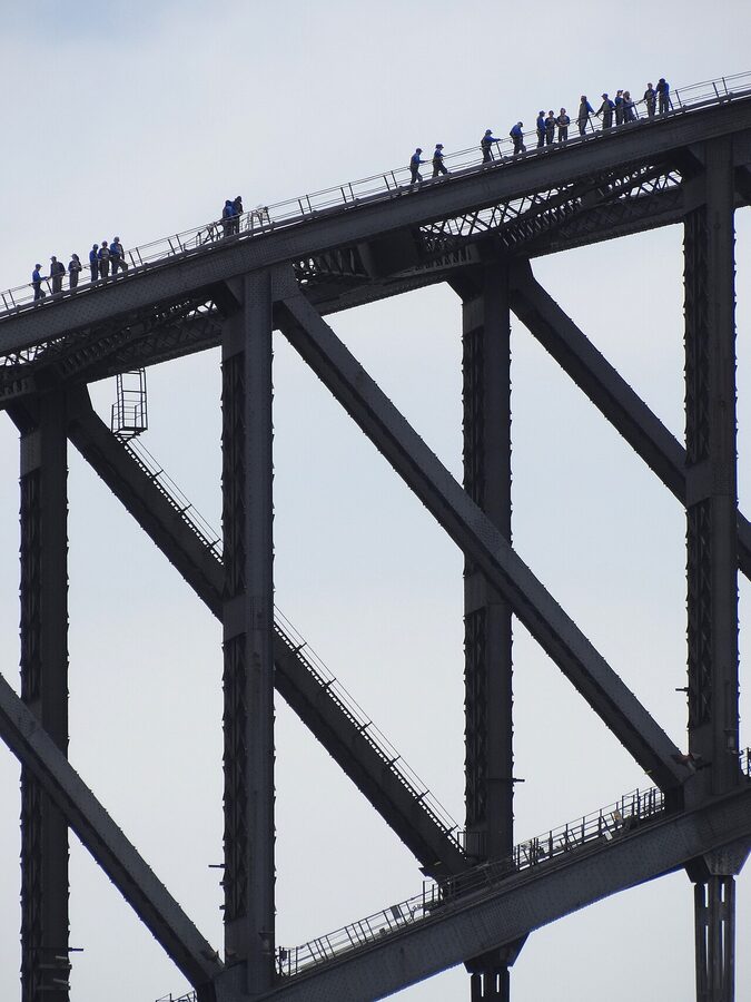 Visitors at the summit of Sydney Harbour Bridge with harbour and skyline behind