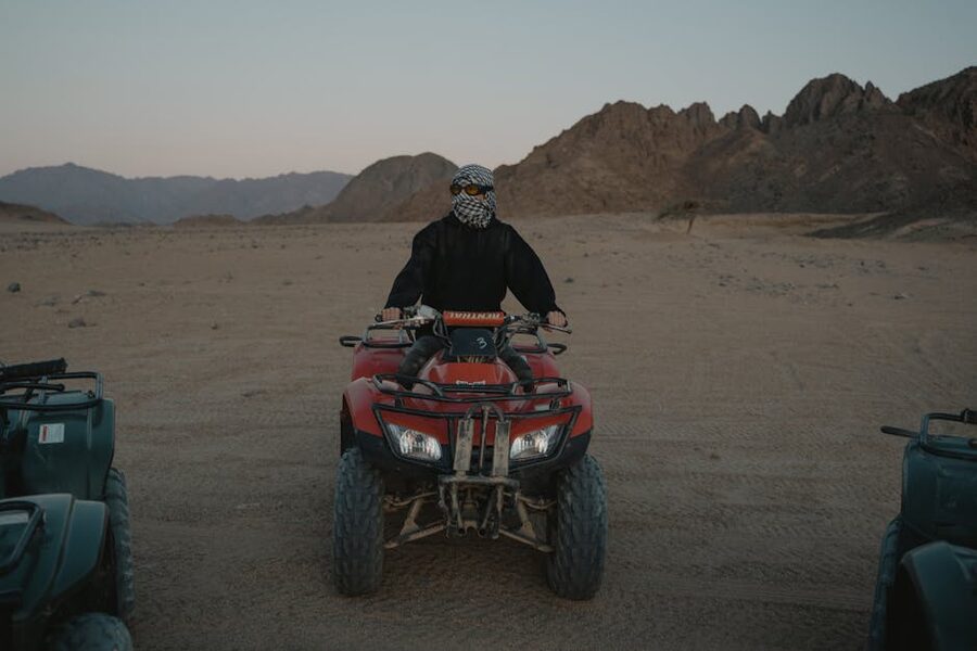 ATV rider with scarf and sunglasses in a rocky desert