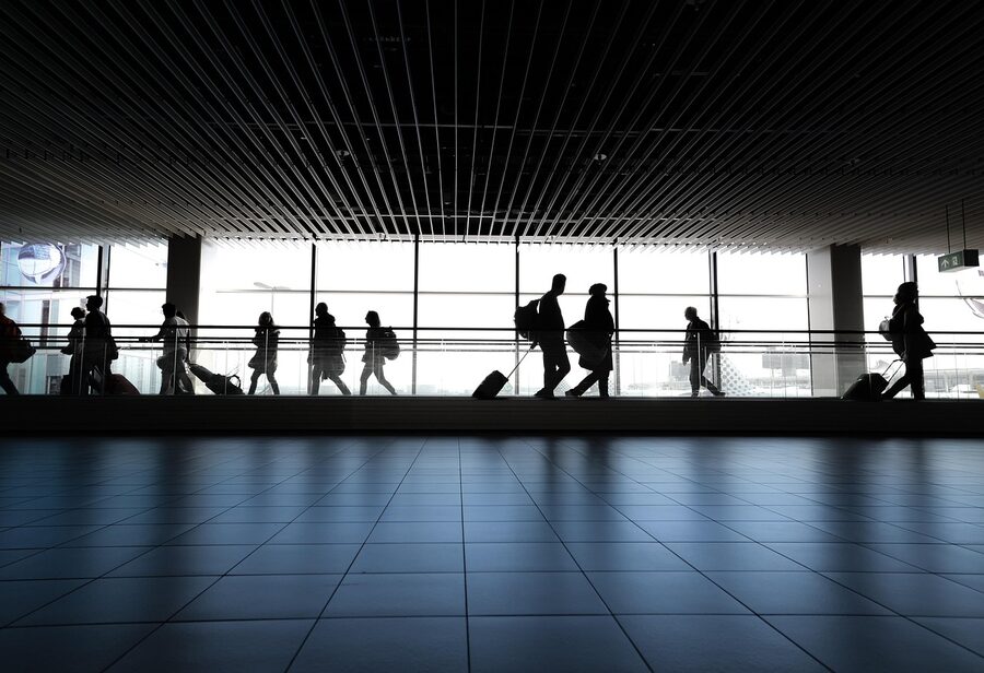 Solo traveler walking through airport terminal with suitcase