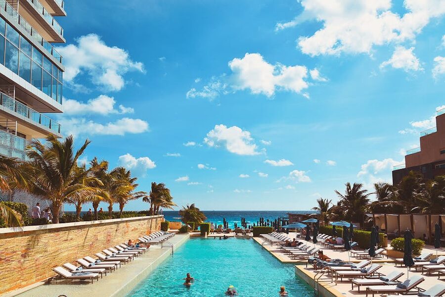 Beachfront pool at a Cancun luxury resort with palm trees