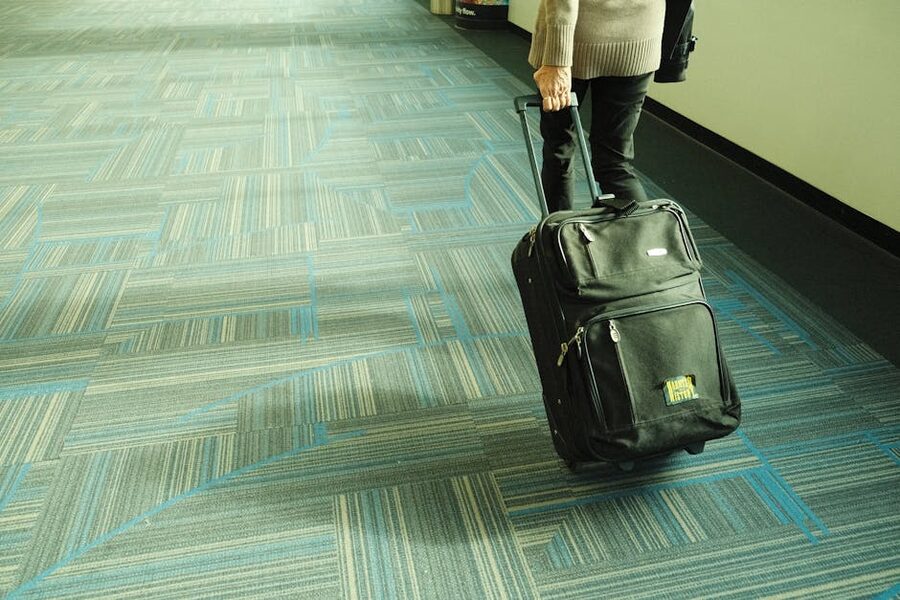 Traveler walking with luggage through airport corridor