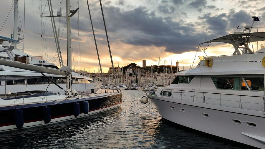 A boat in Cannes Vieux Port with the historic centre behind