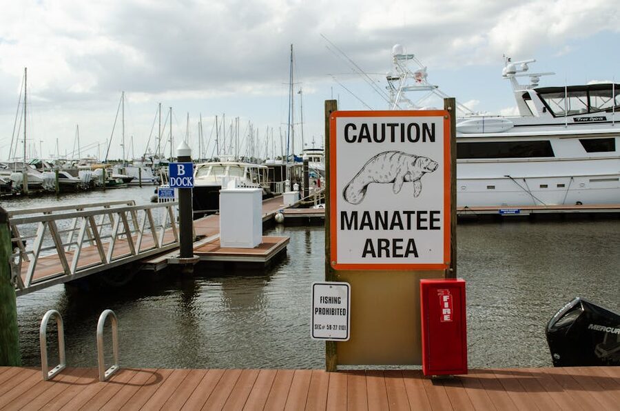 Caution manatee area sign at a Florida marina with boats in background