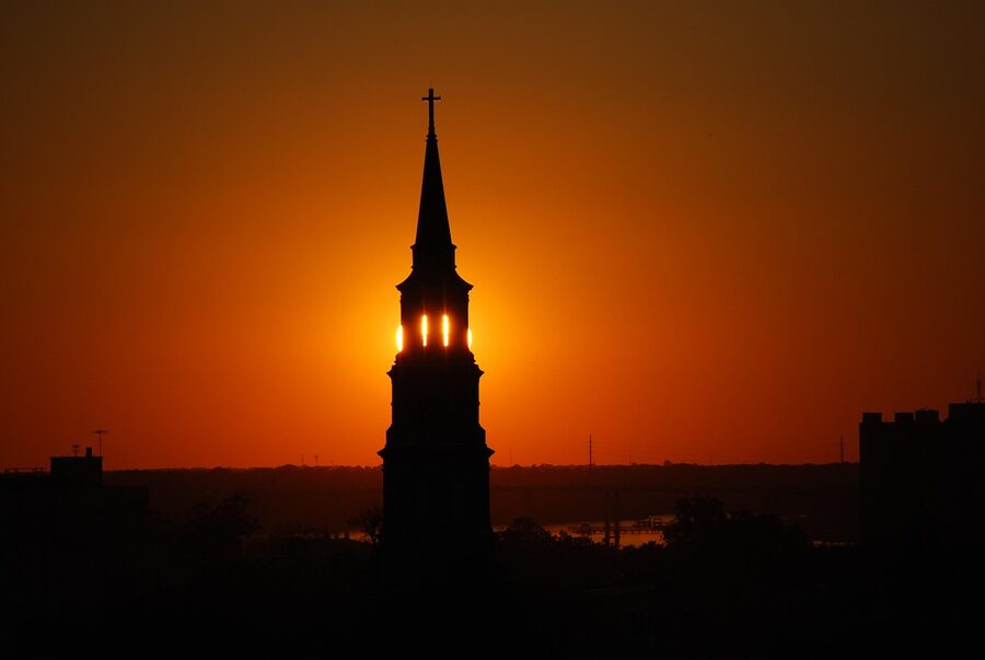 Charleston church steeple silhouetted against golden sunset