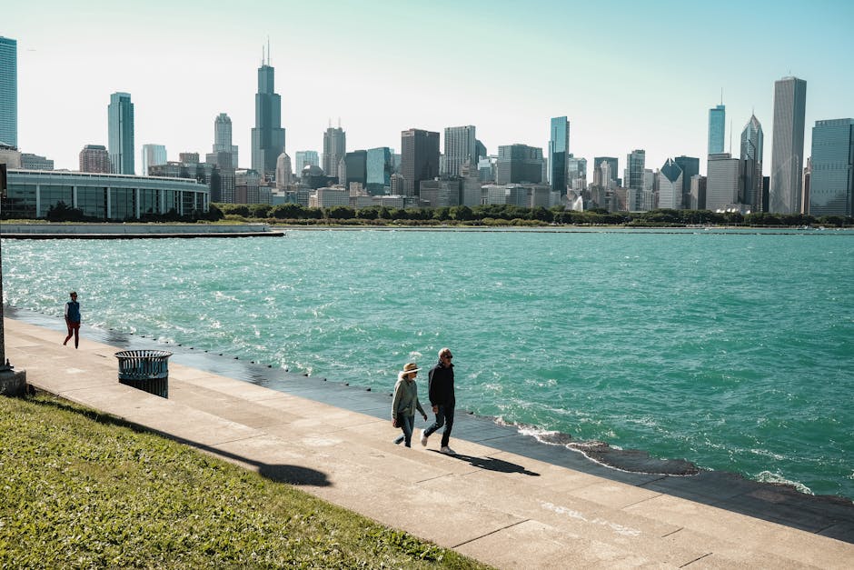 Chicago skyline overlooking Lake Michigan with people walking by the promenade