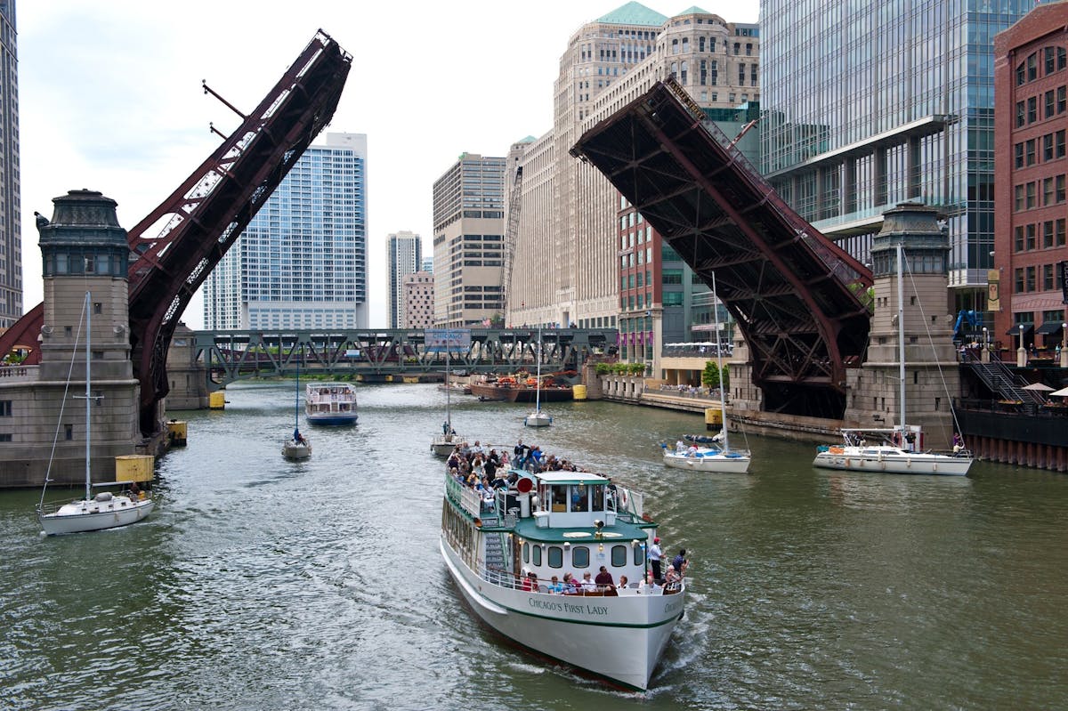 Chicago River with raised bridges and tour boats on a sunny day