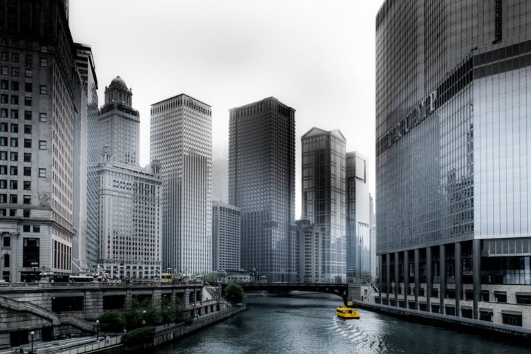 Tour boat on the Chicago River passing between towering skyscrapers on a sunny day