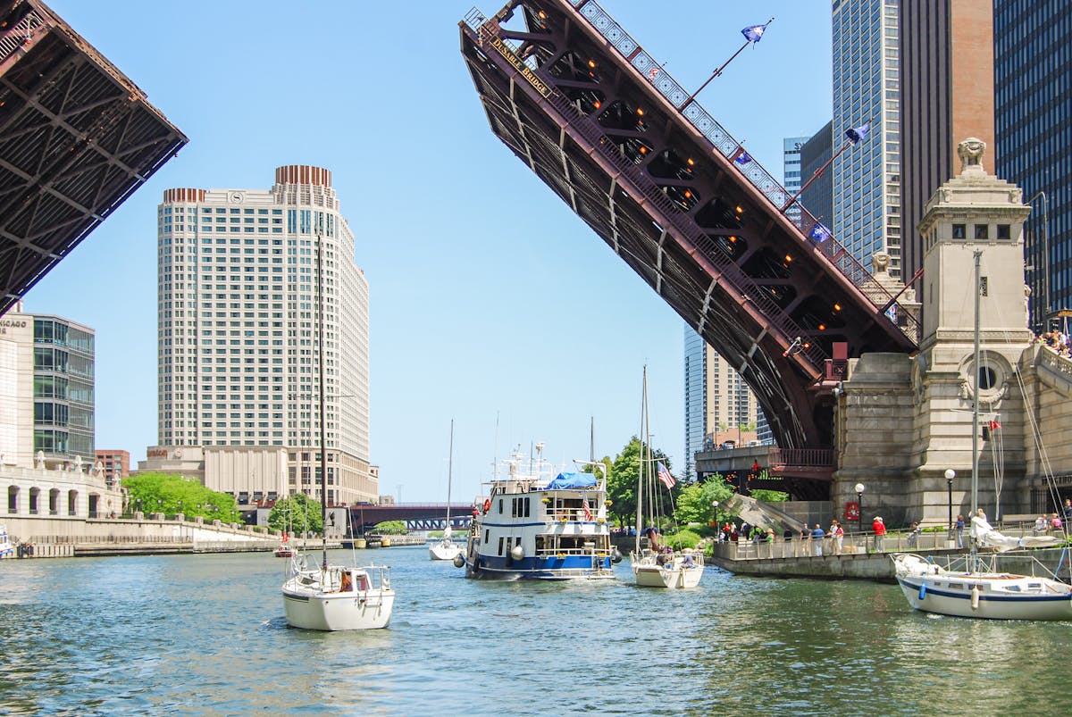 DuSable Bridge raised over the Chicago River with surrounding cityscape and tour boats