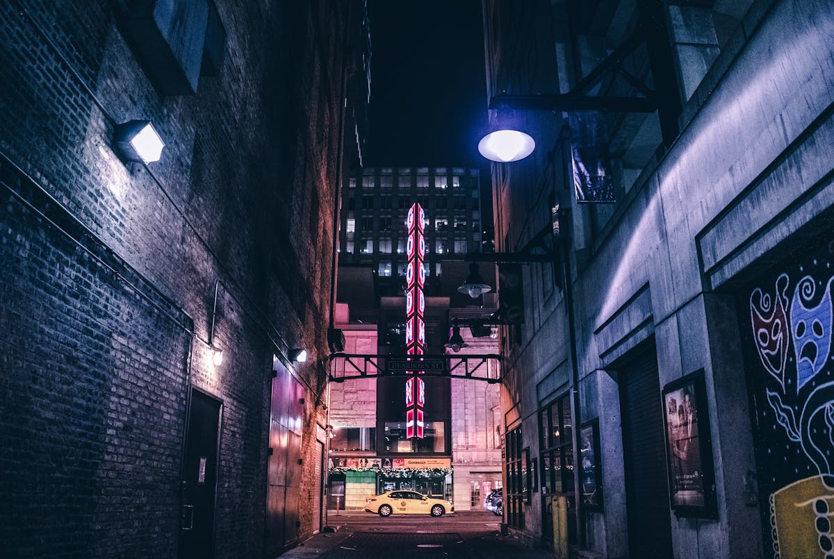 Moody Chicago alley at night with vintage theater signs and dramatic lighting