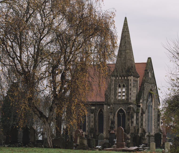 Gothic church surrounded by cemetery and autumn trees