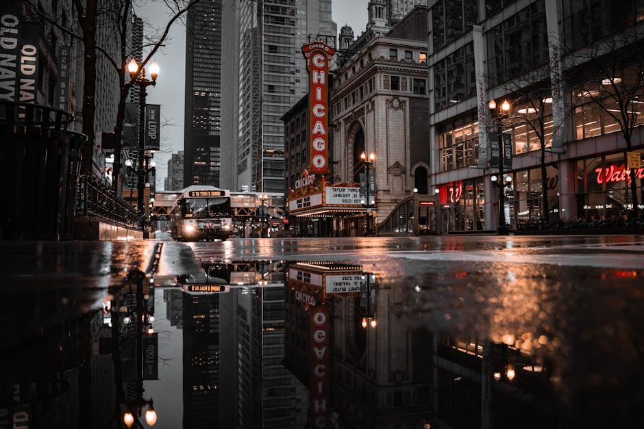 Chicago Theatre marquee with city lights reflecting in street puddle