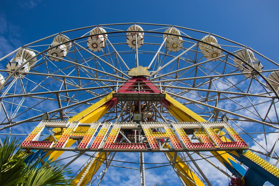 Low-angle view of Ferris wheel against clear blue sky
