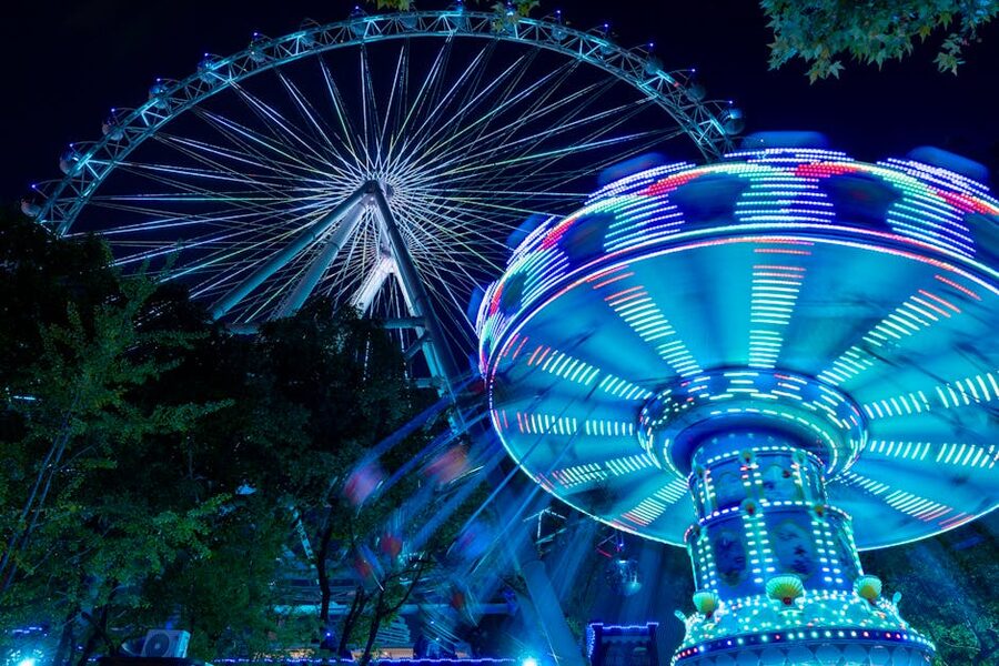 Ferris wheel and carousel lit up at night