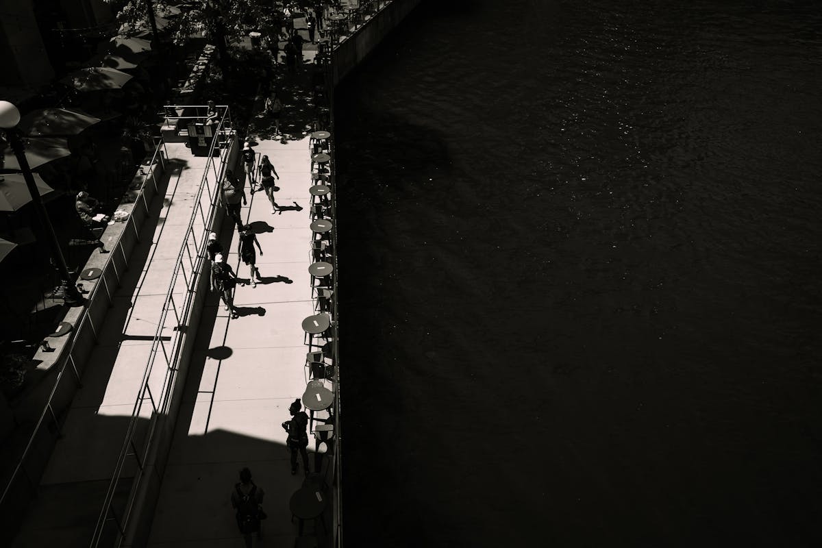 Aerial view of people walking along the Chicago Riverwalk next to the river