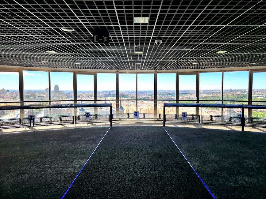 Inside an observation deck with panoramic city skyline through large windows