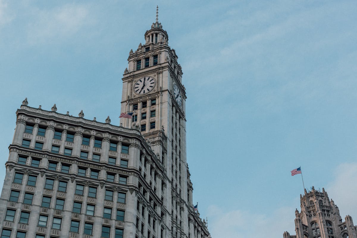 Low-angle shot of the Wrigley Building under a clear blue sky in Chicago