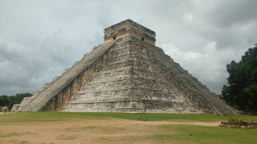 El Castillo pyramid rising above green lawn at Chichen Itza