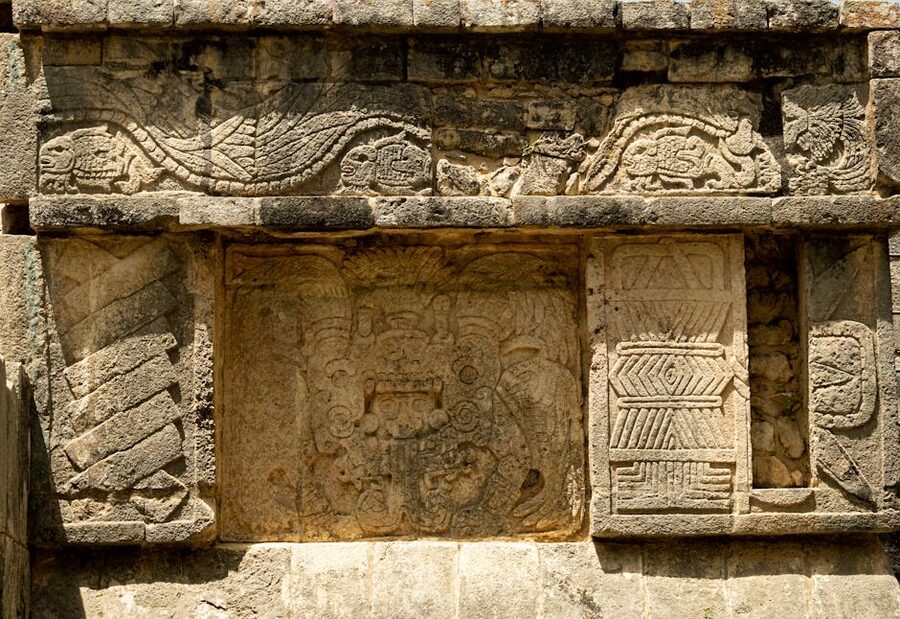 Detailed Mayan stone carvings on a wall at Chichen Itza