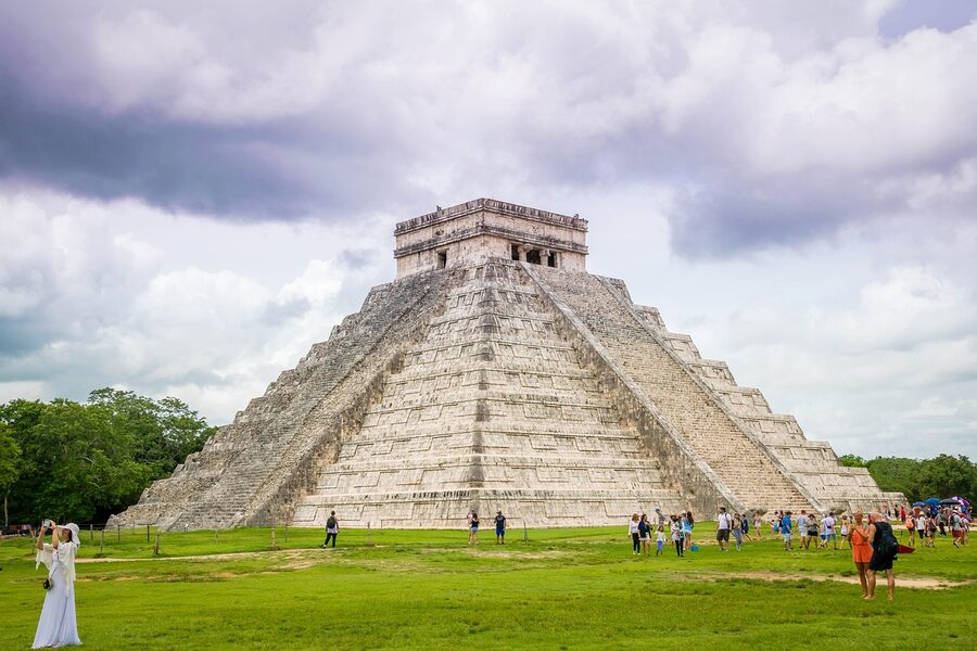 Chichen Itza ruins with visitors walking among stone structures