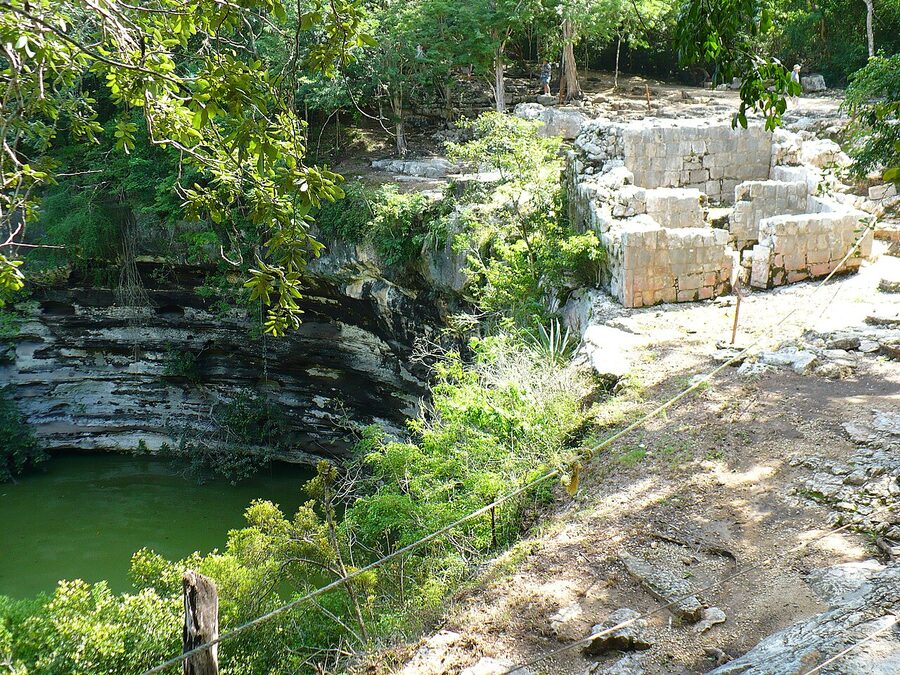 Sacred Cenote at Chichen Itza with steep stone walls and green water