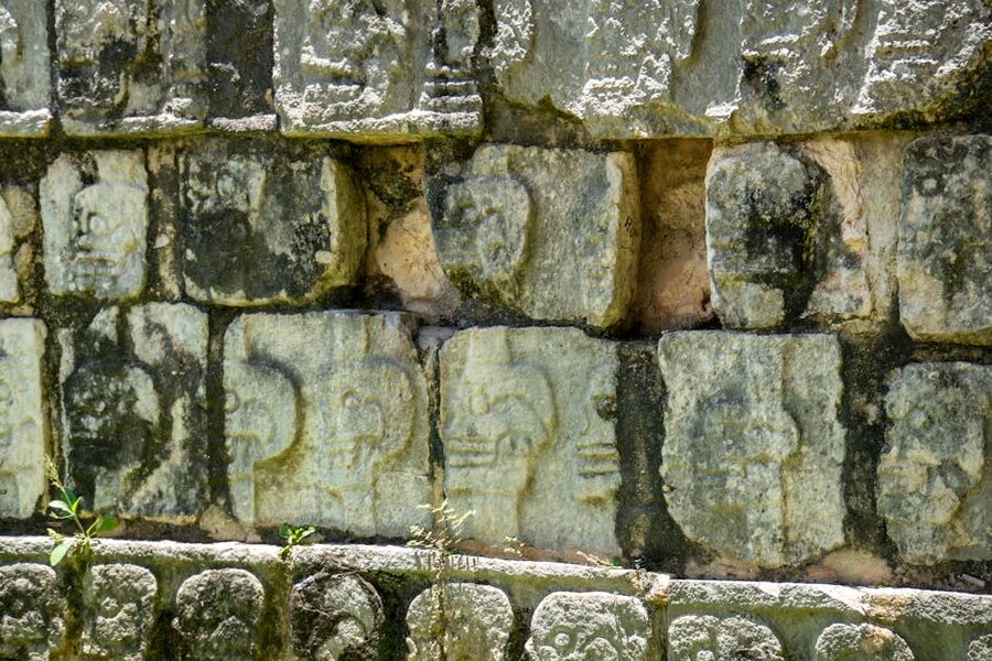 Skull wall Tzompantli carvings on stone at Chichen Itza