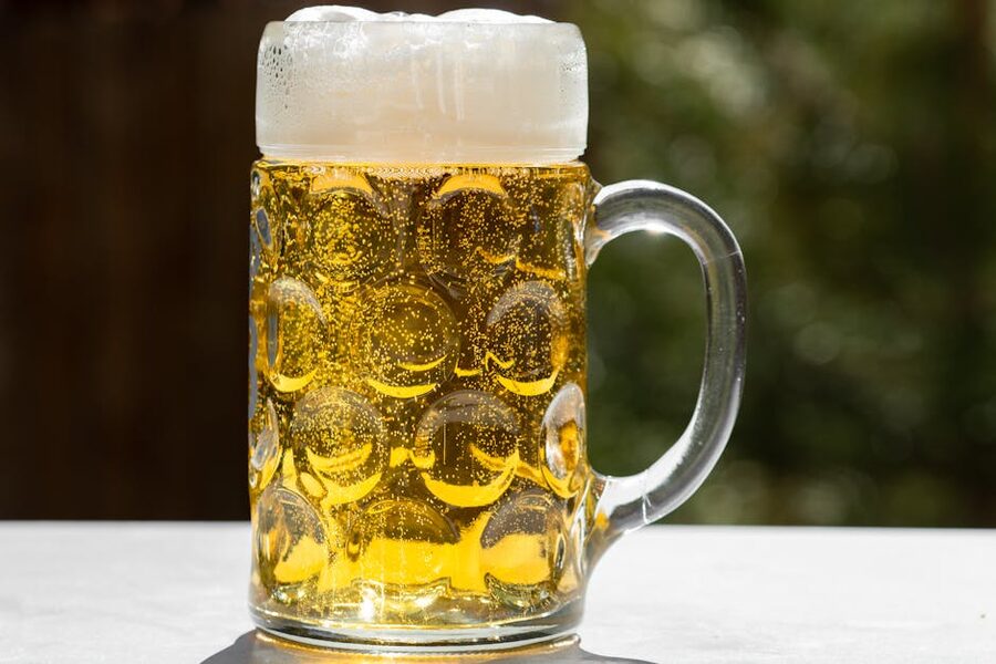 Golden lager beer with frothy head in glass