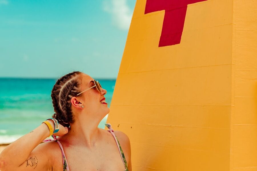 Woman with beach braids near a lifeguard tower on a Mexican Caribbean beach