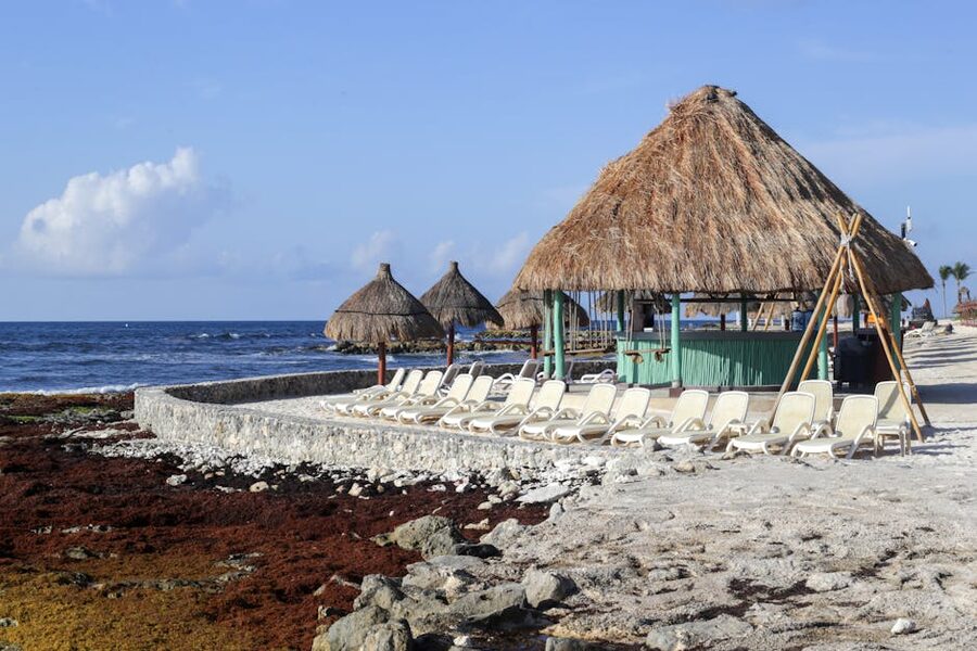 Palapa huts and sun loungers on a white sand Caribbean beach
