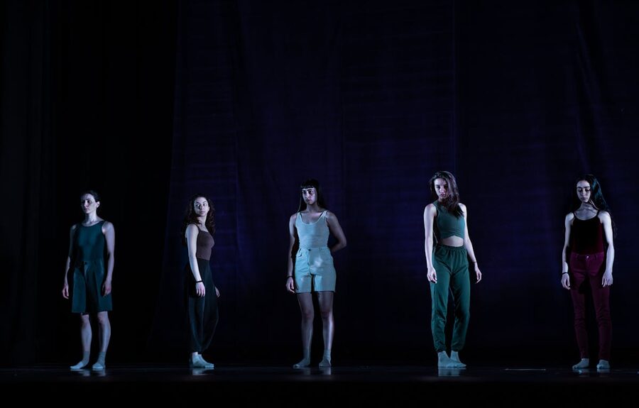 Women dancers posing dramatically on dimly lit stage