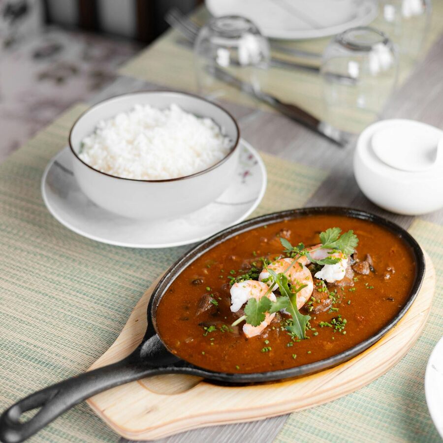 Creole shrimp etouffee served with rice on a rustic table