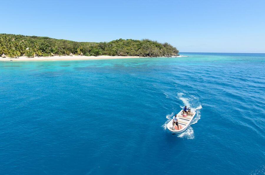 Aerial view of a tropical Mamanuca island with a motorboat in clear blue water